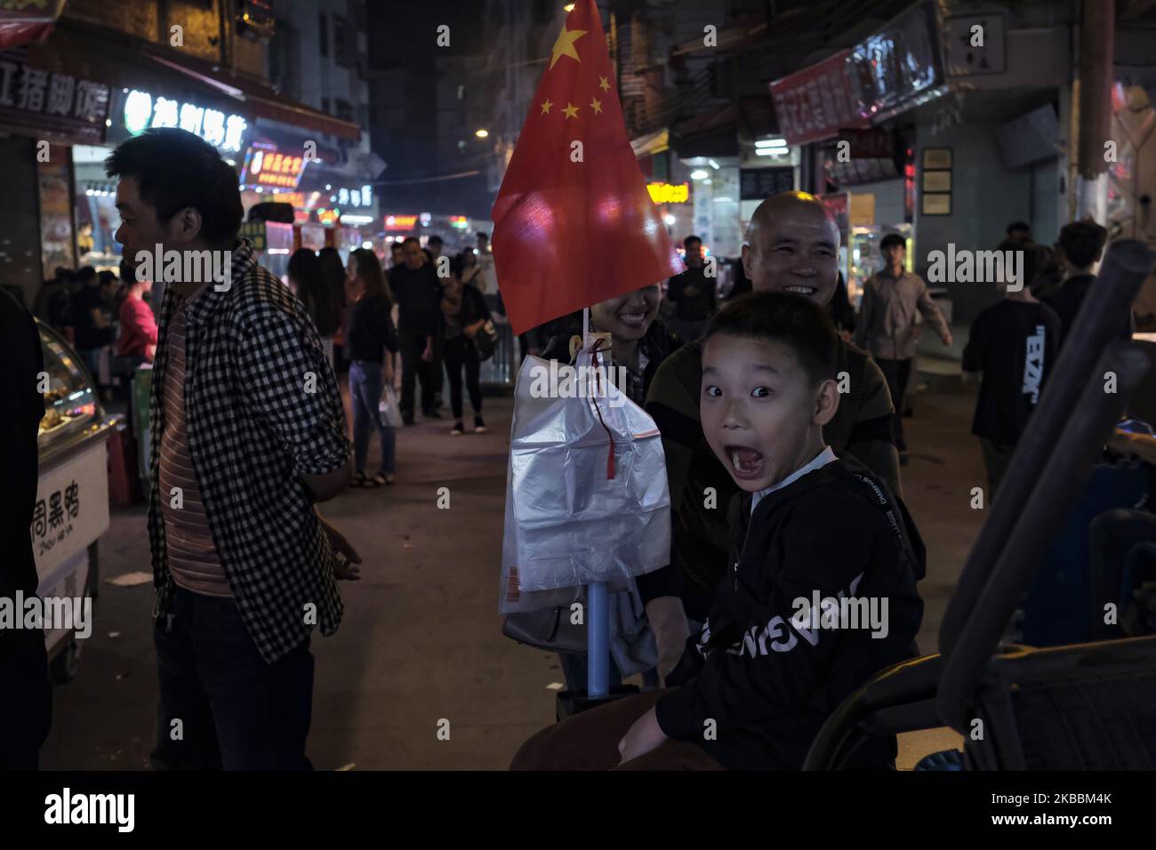 Chinese walk on a busy street at night in the city of Guangzhou in ...