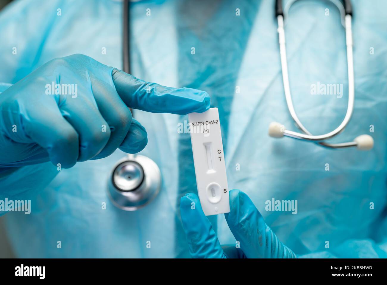 Asian doctor in PPE suit holding Saliva Antigen Test Kit for check ...