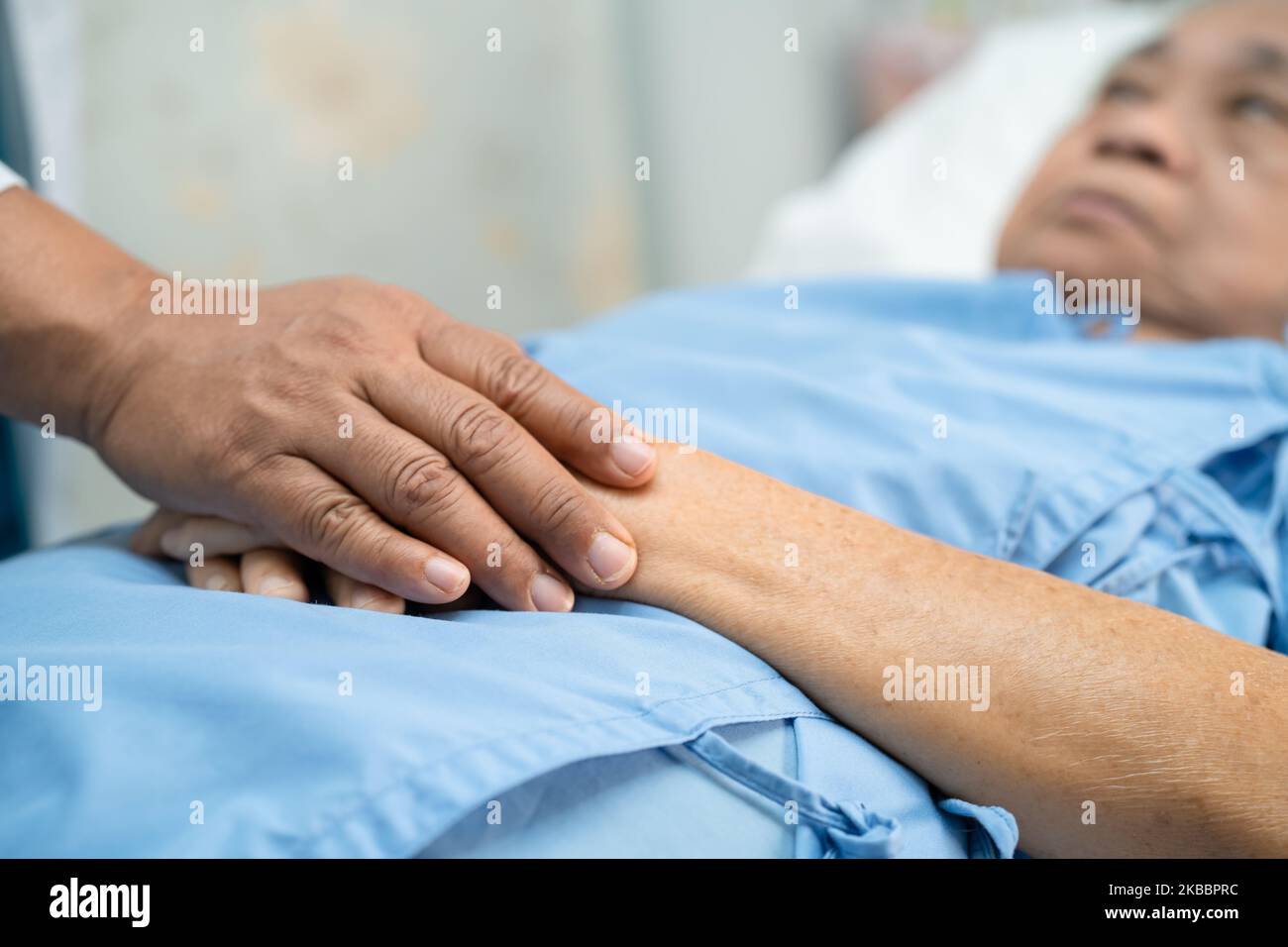 Doctor holding touching hands Asian senior or elderly old lady woman ...