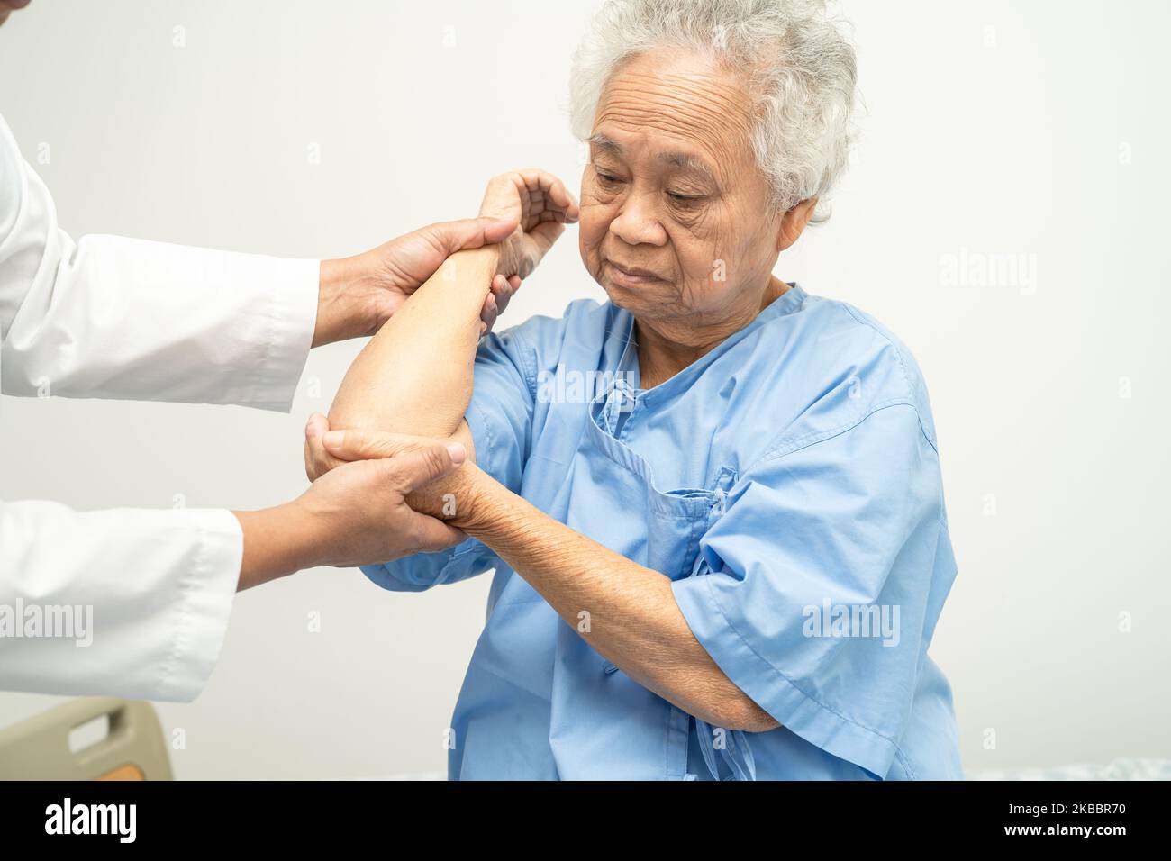 Asian senior or elderly old lady woman patient feel pain her elbow on ...