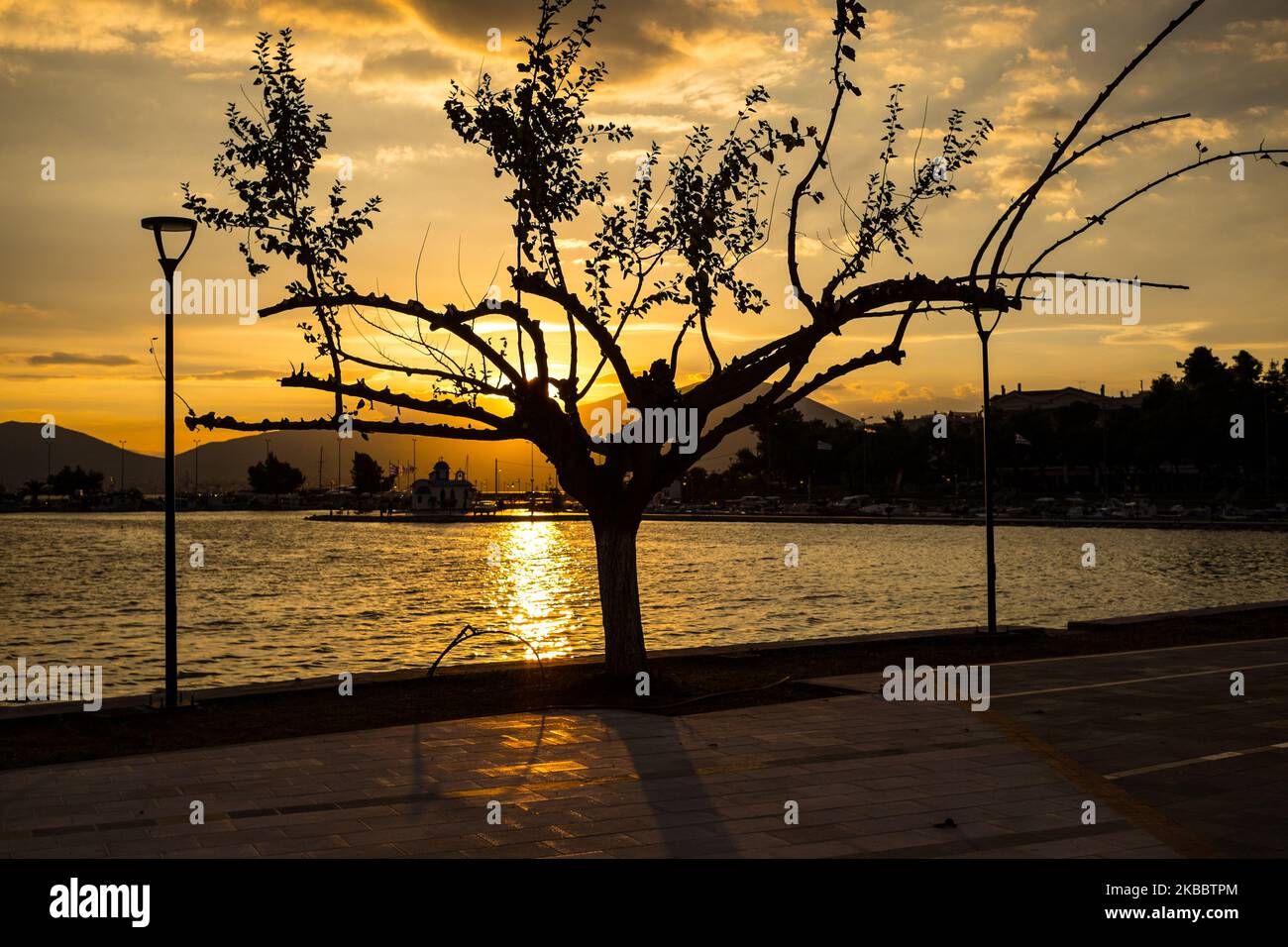 Sunset with clouds in the sky at the harbor of Nea Artaki on the island ...