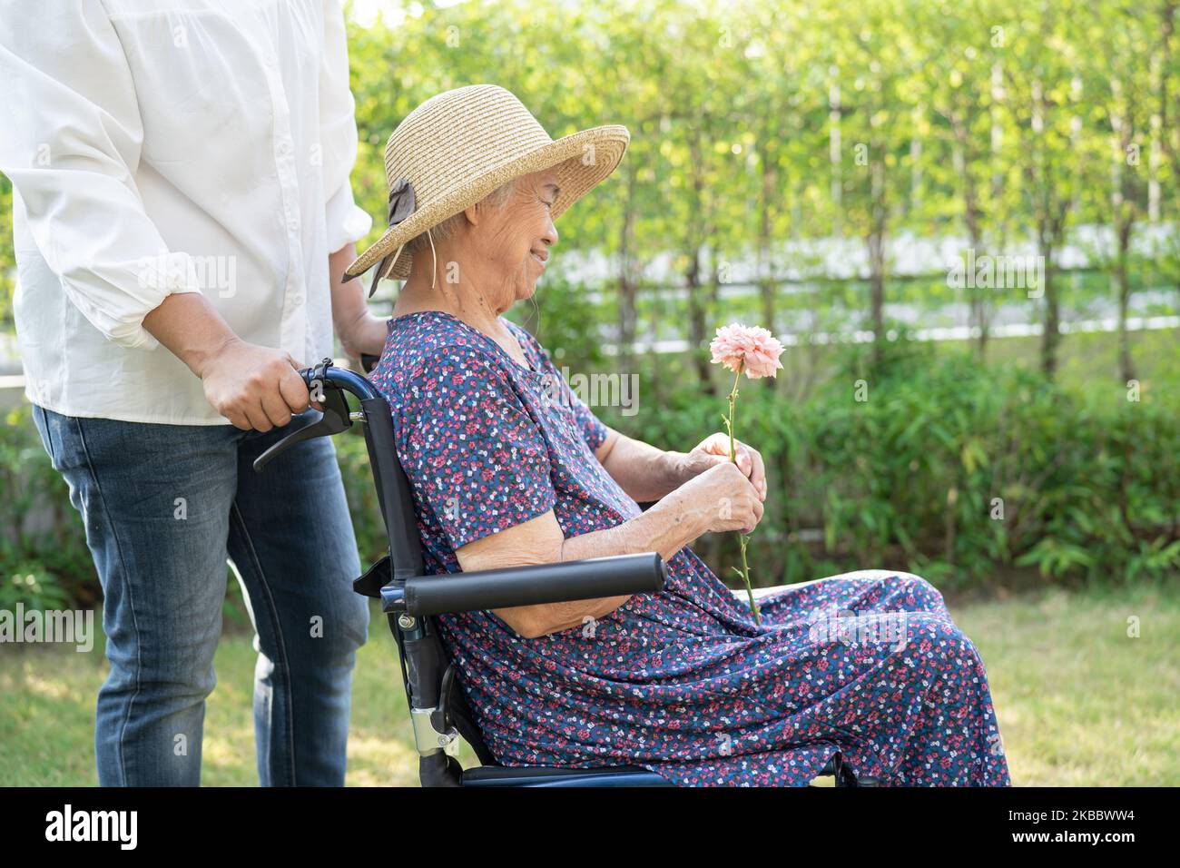 Caregiver help and care Asian senior or elderly old lady woman patient ...