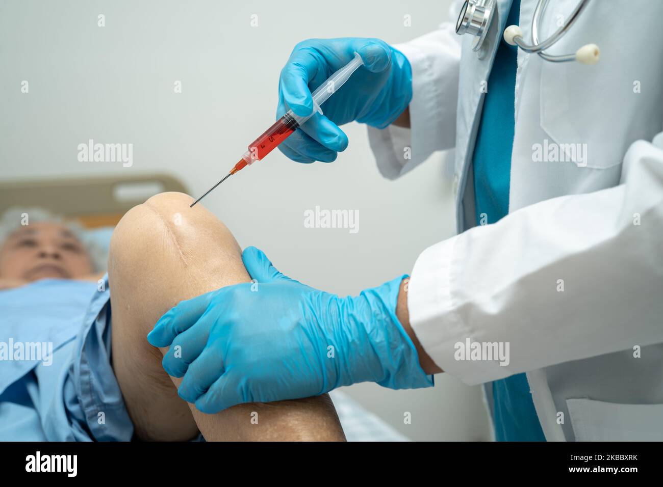 Asian doctor inject Hyaluronic acid platelet rich plasma into the knee of senior woman to walk ...