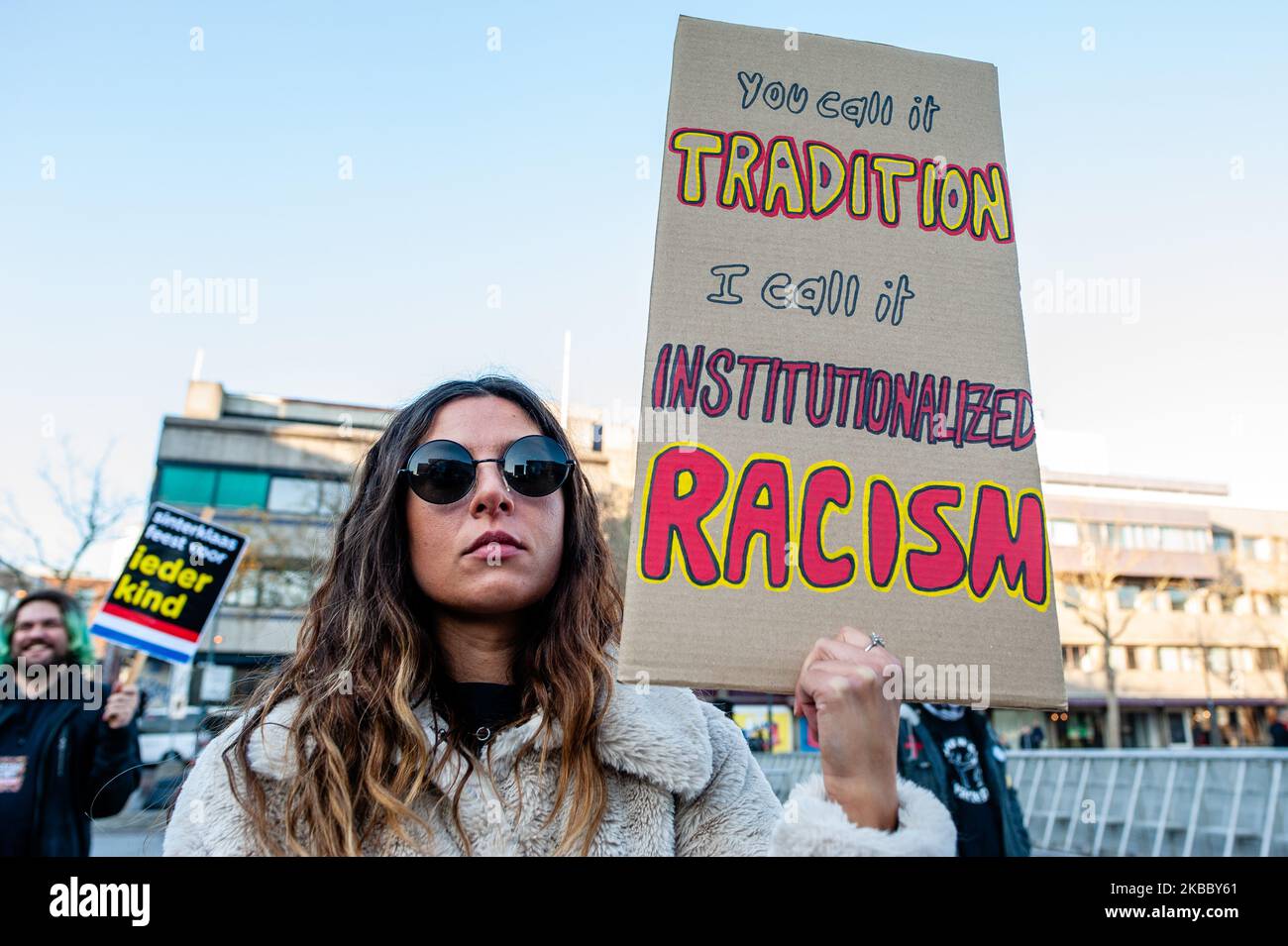 A woman is holding a placard, during the Anti Black Piet rally in ...