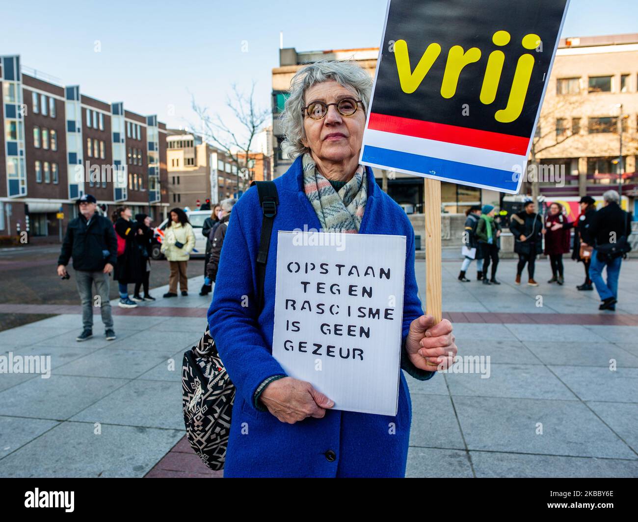 An old woman is holding two placards during the rally Anti Black Piet ...