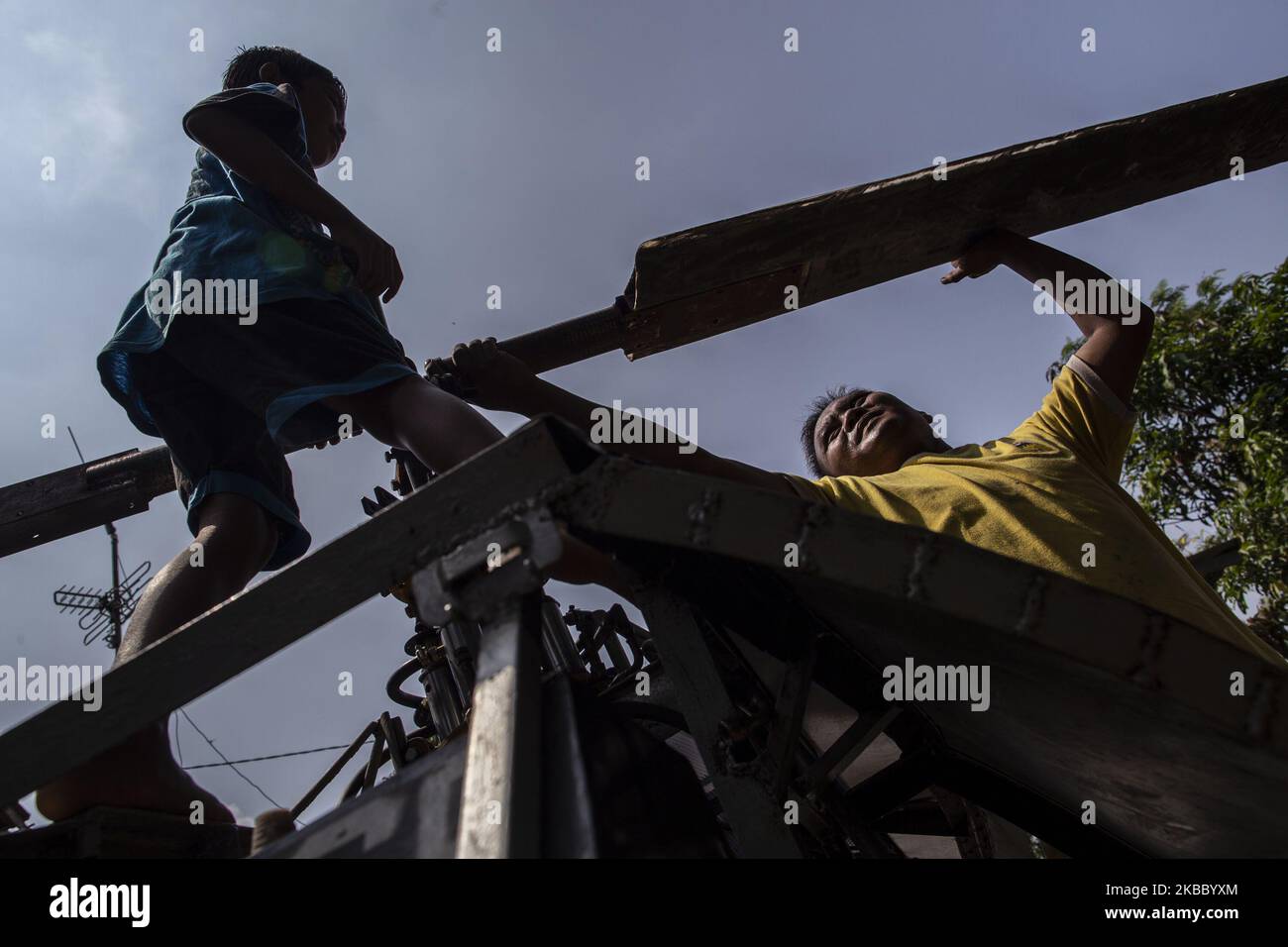 Jujun Junaedi, with his young son Dede Rafka assistant build a ...