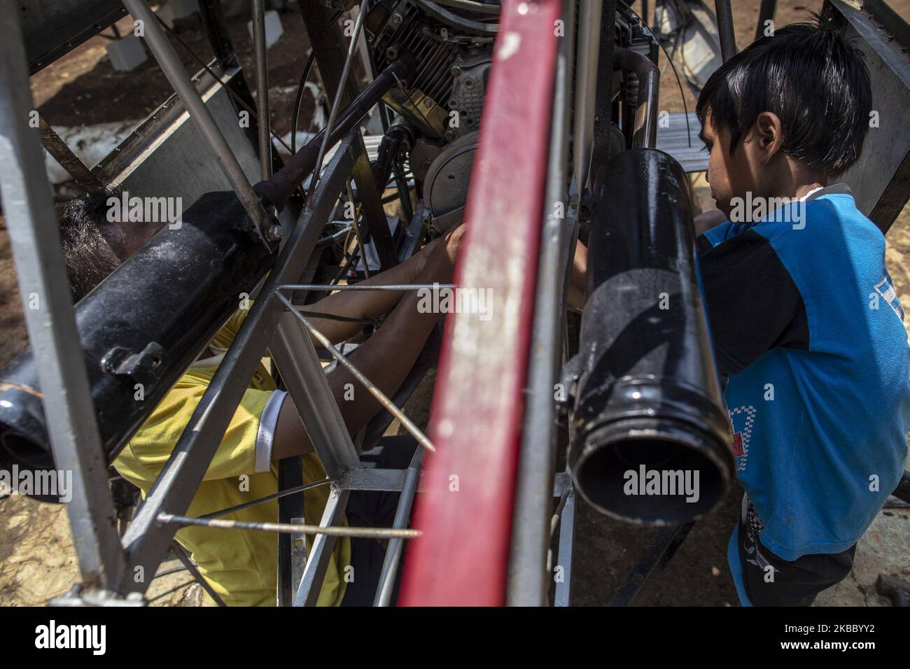 Jujun Junaedi, with his young son Dede Rafka assistant build a ...