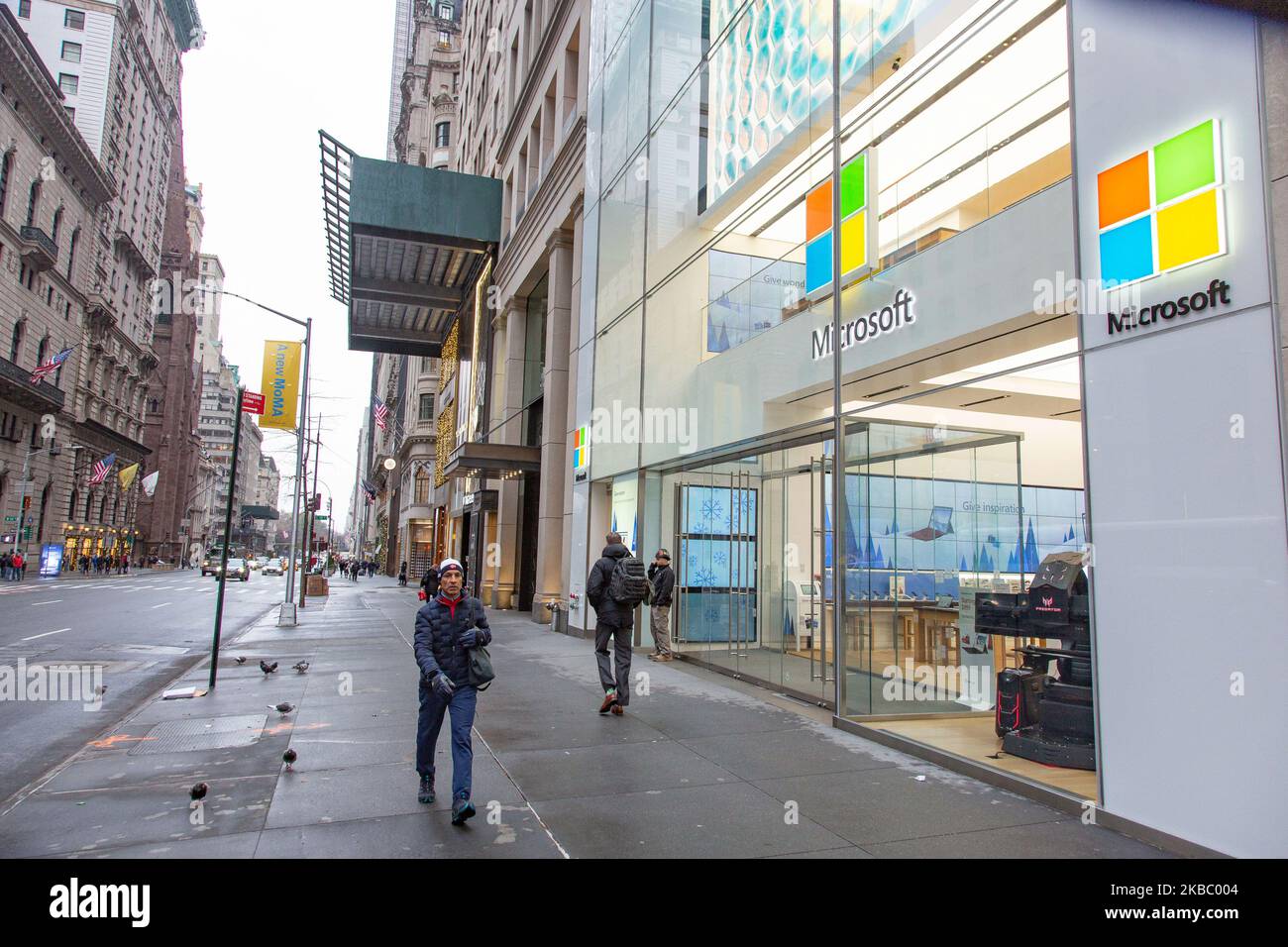 People walk past a Microsoft store entrance with the company's logo on ...