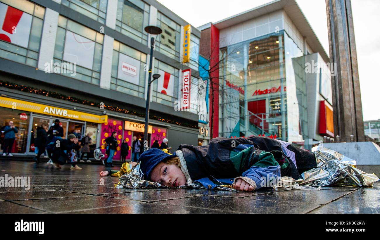 A group of XR activists are lying on the floor while performing a fake ...