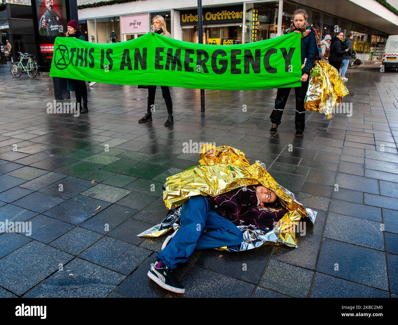 A XR activist is lying on the floor in front of a big XR banner, during ...