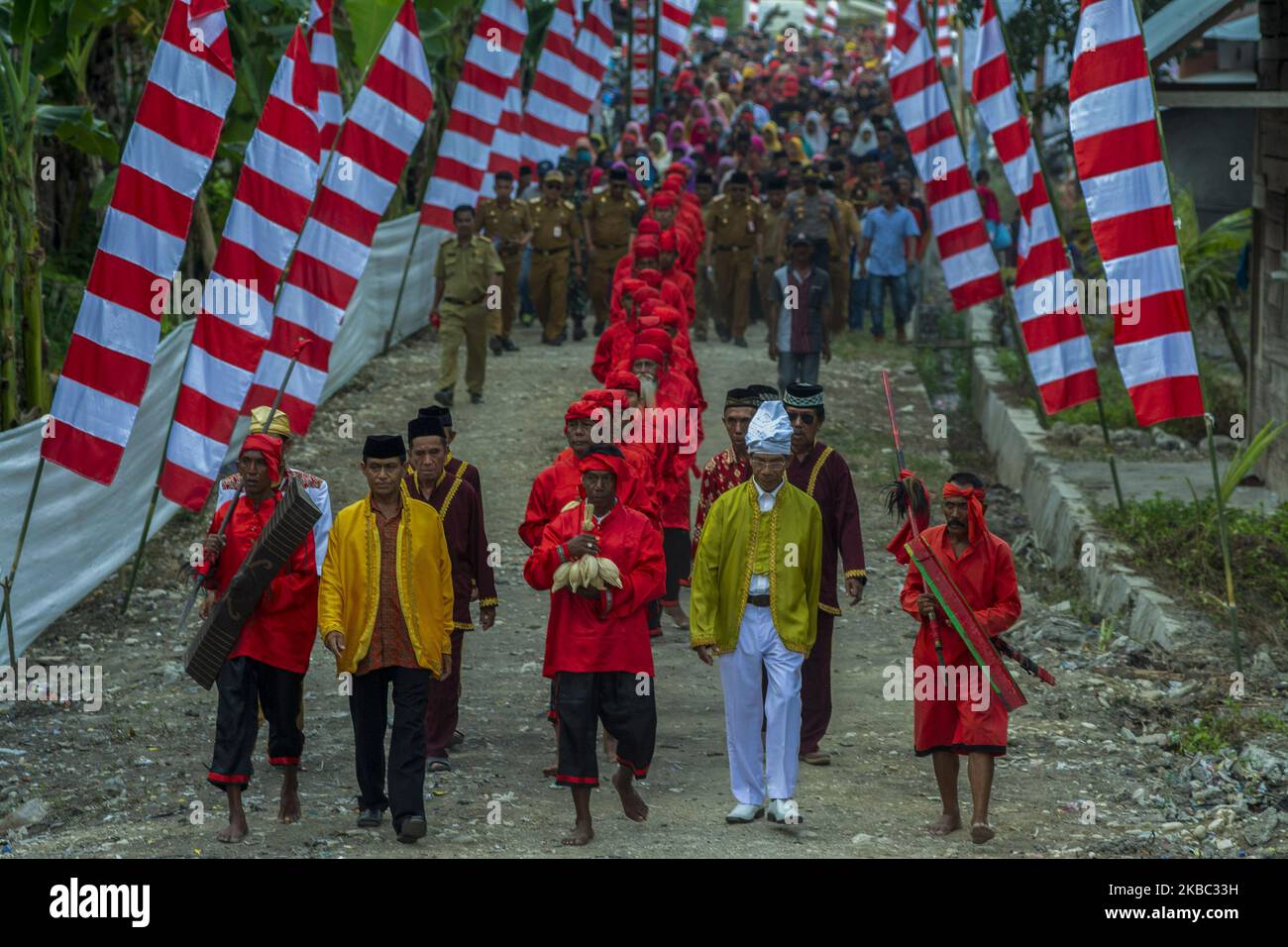 The Batui indigenous people are accompanied by local residents carrying ...