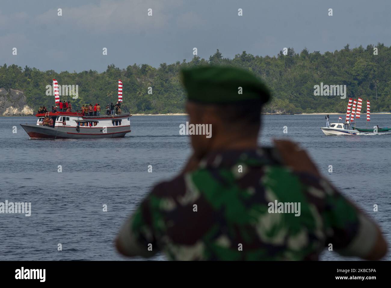 A soldier takes a photo of a boat convoy delivering maleo eggs ...