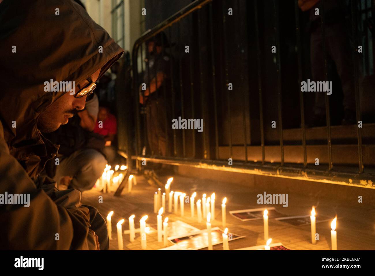 Demonstrators light candles during a protest about the death of nine ...