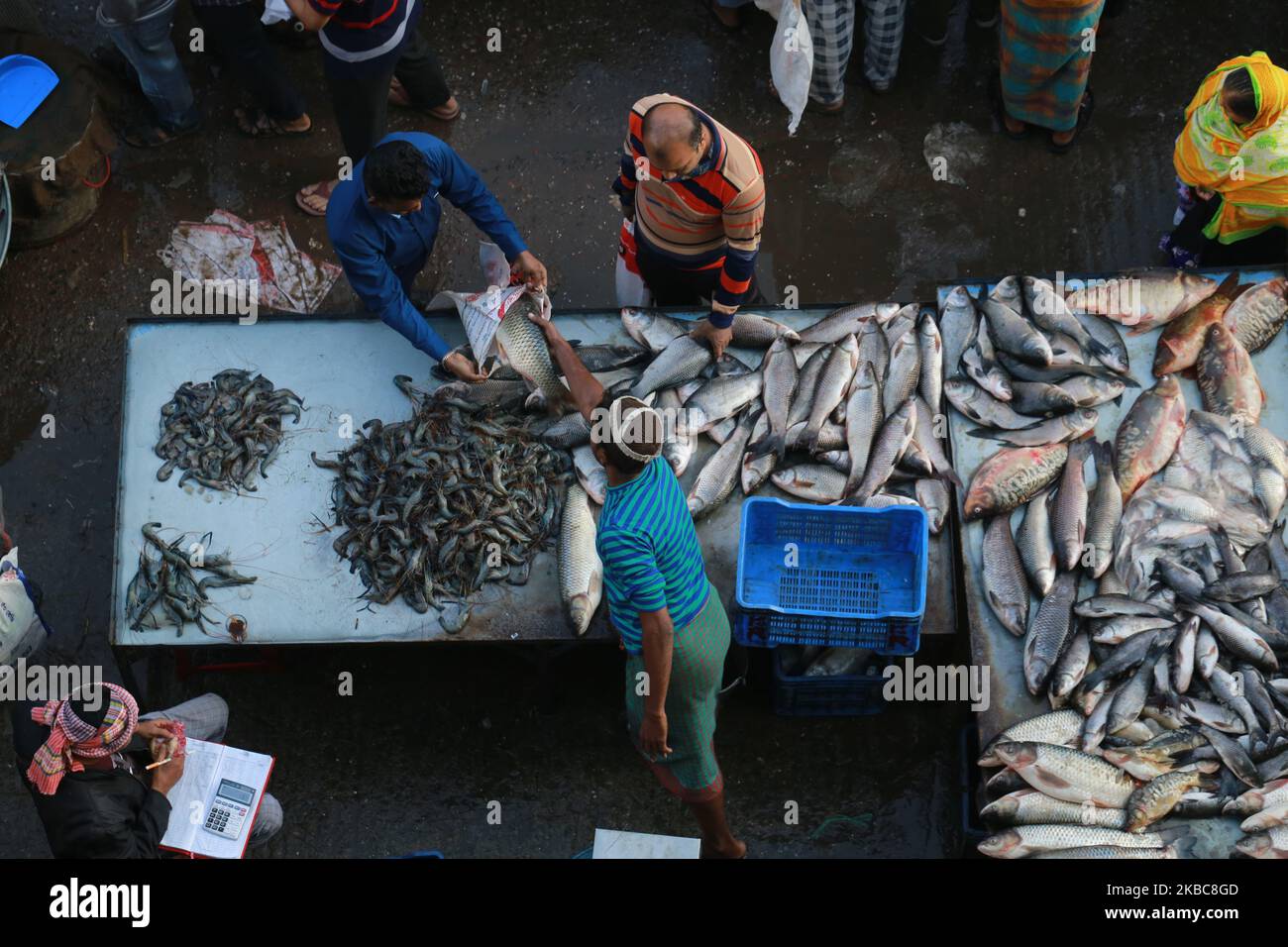 People buy fishes at a wholesale fish market in Dhaka, Bangladesh on ...