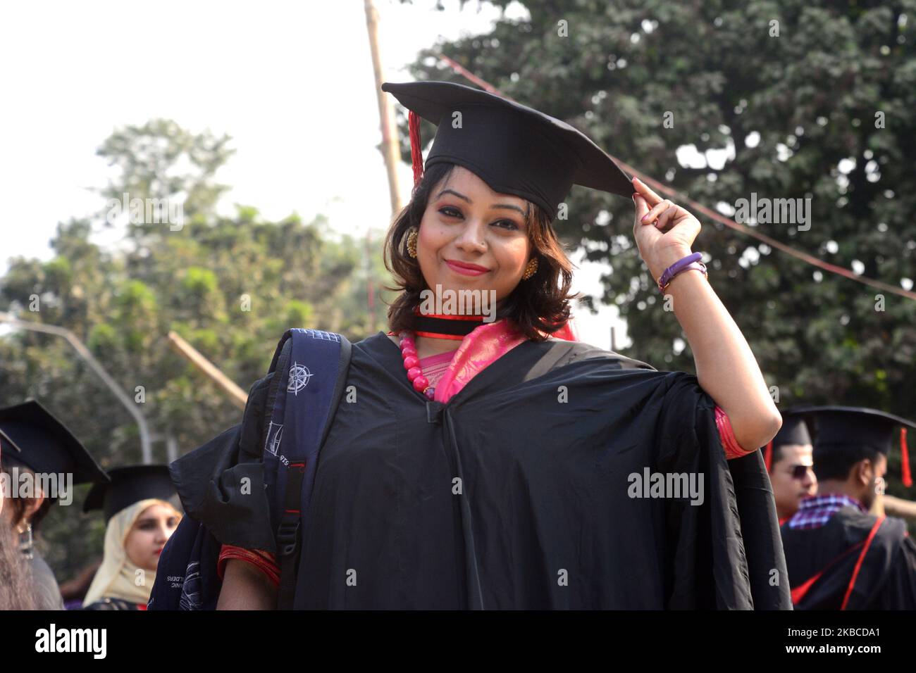 A group of graduates expressing their delight in front of the sculpture ...