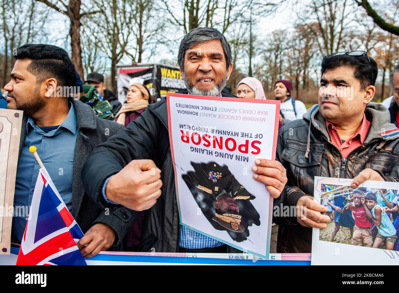A man is seen hitting a poster with a photo of the president of Myanmar ...