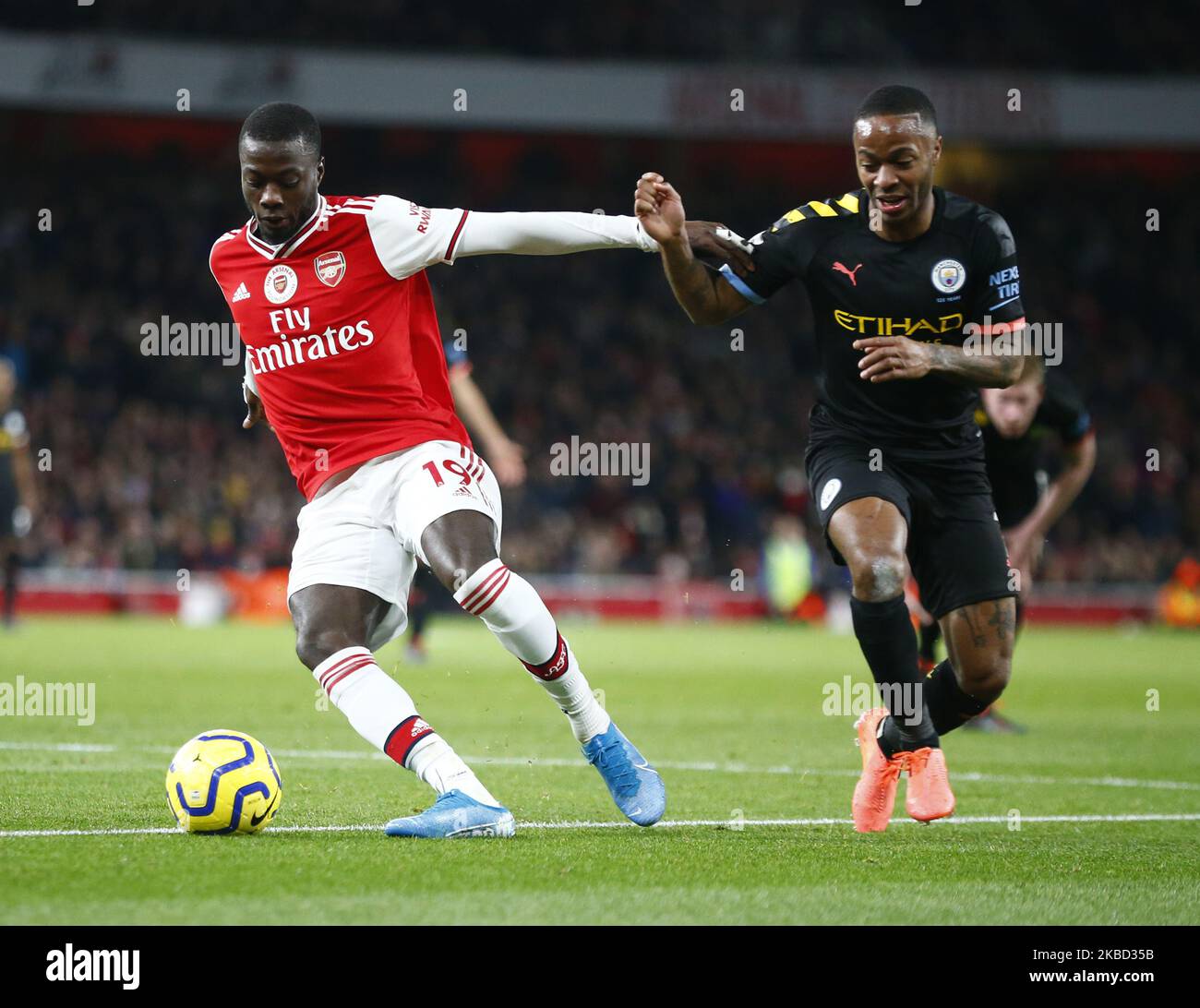 Nicolas Pepe of Arsenal holds of Manchester City's Raheem Sterling ...