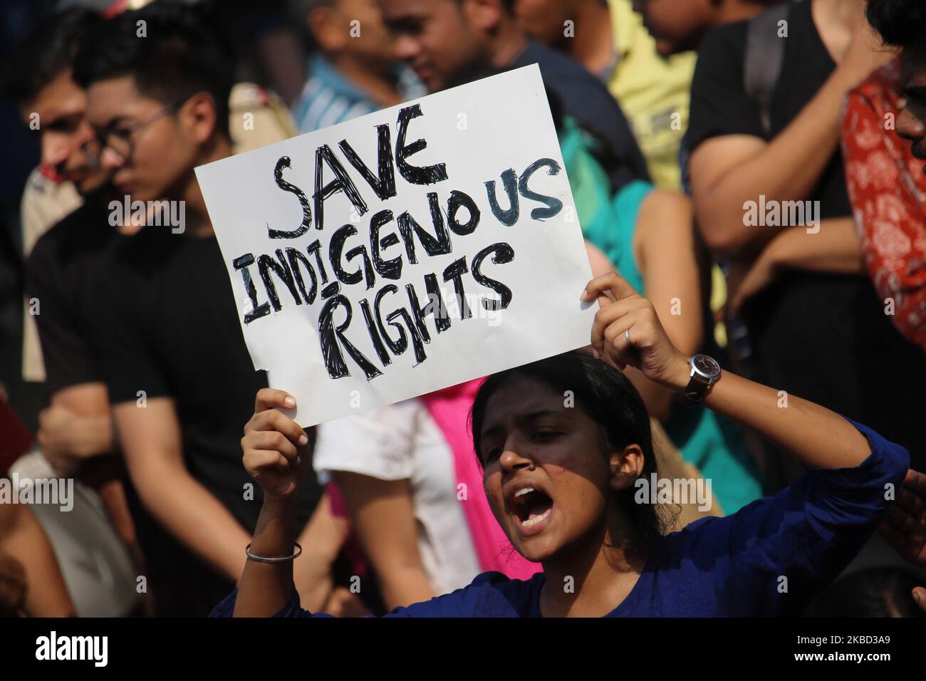 A student holds a placard and shouts slogans during a protest against ...