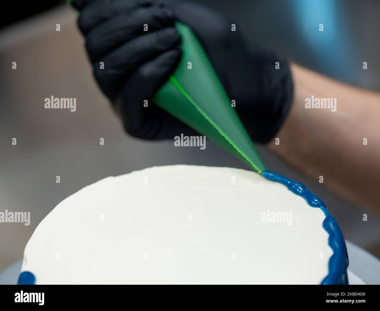 pastry chef cake designer preparing blue white cheesecake in kitchen ...