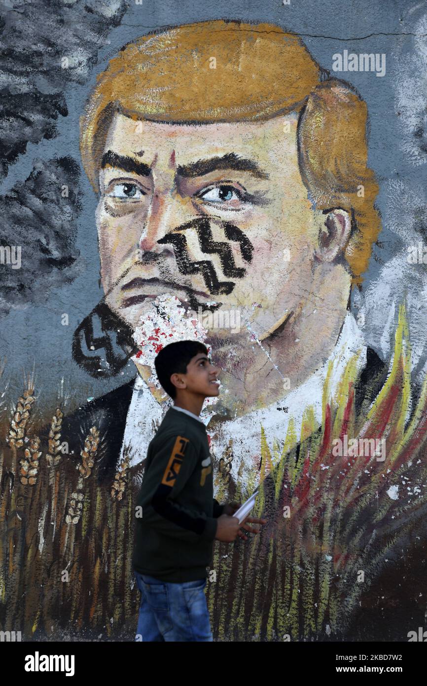 A boy walks next a graffiti mural depicting US President Donald Trump ...