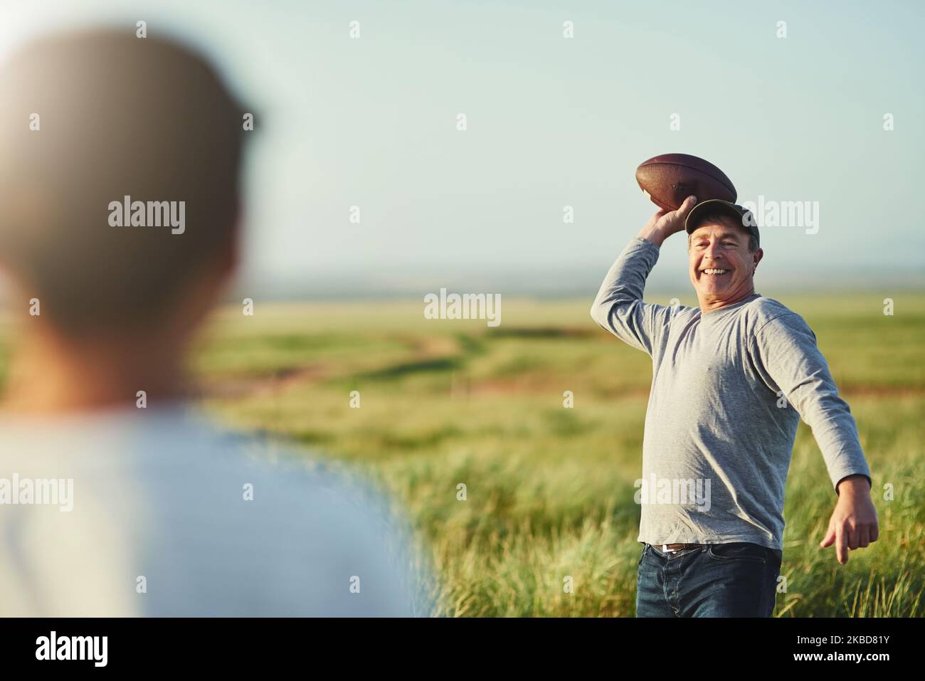 Get ready, its coming your way. father throwing a football to his son ...