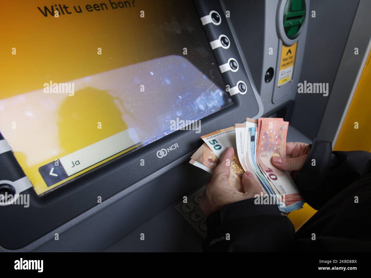 People uses ATM machine on the street in the New West district of ...