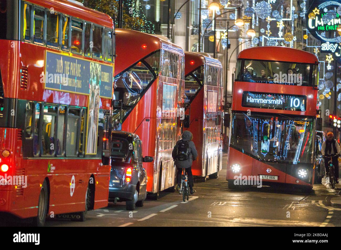 A man rides a bicycle through the buses on Oxford Street , in London , England , 20 December ...