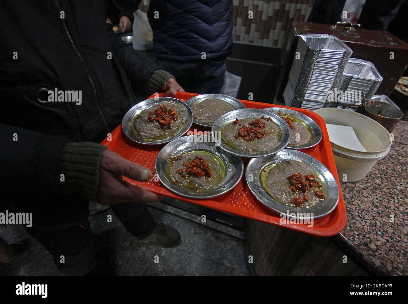 A waiter serving Harisa to customers on a cold morning in Srinagar ...