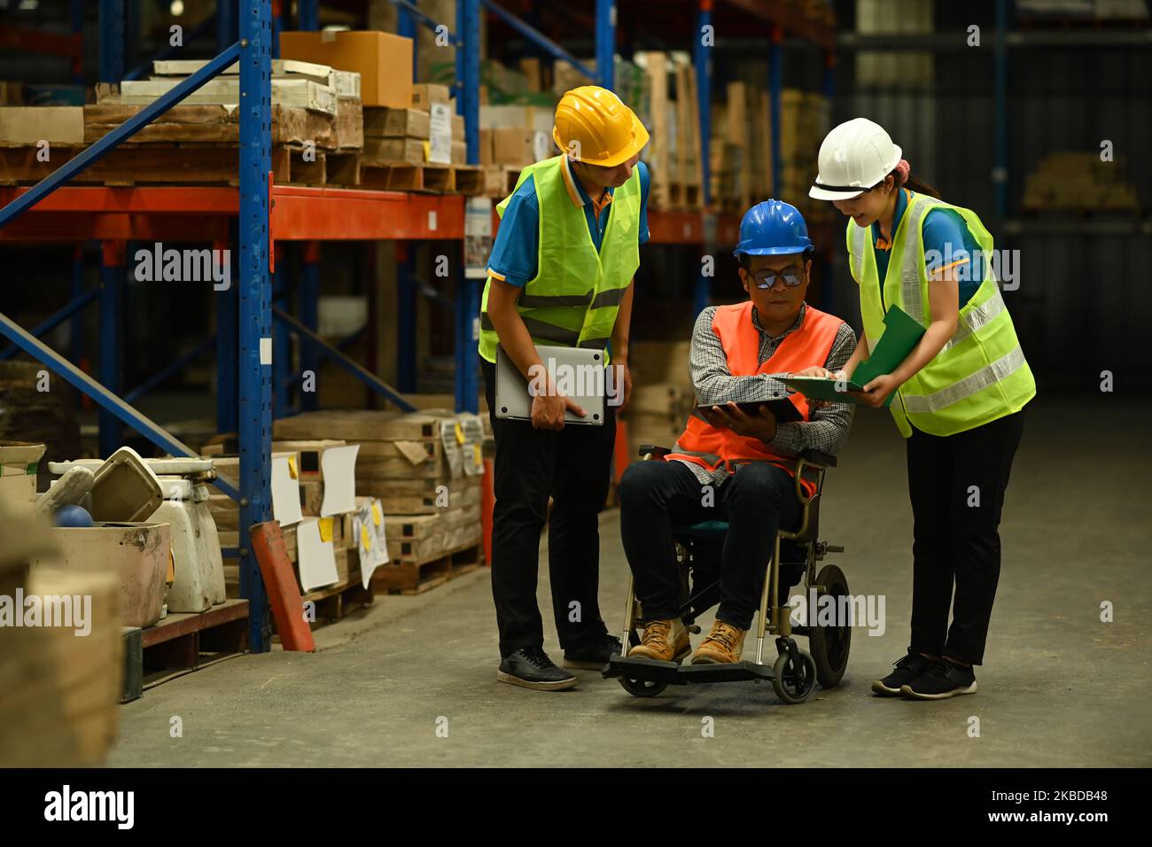 Warehouse workers working in the retail warehouse full of shelves with ...