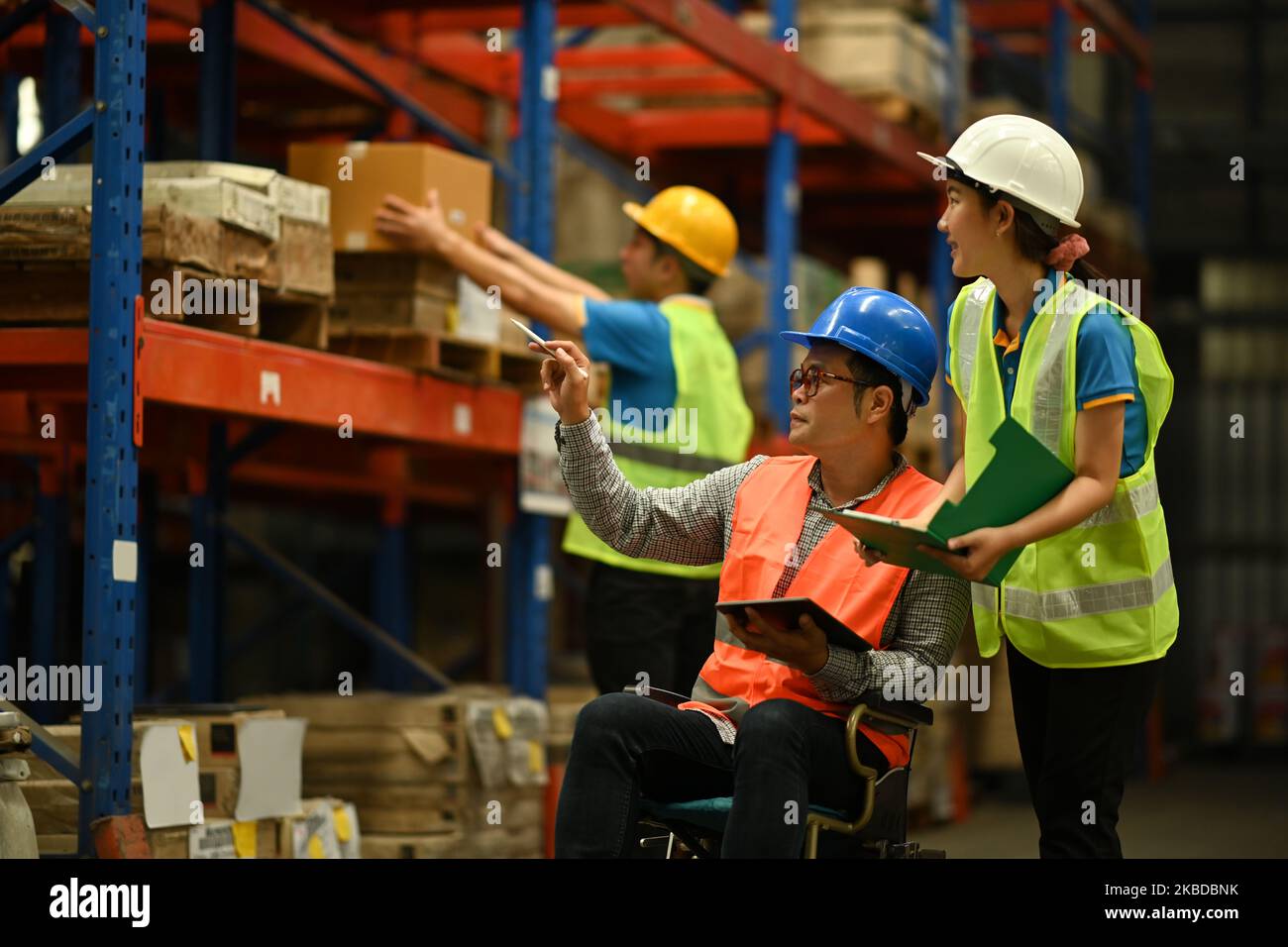 Warehouse workers working in the retail warehouse full of shelves with ...
