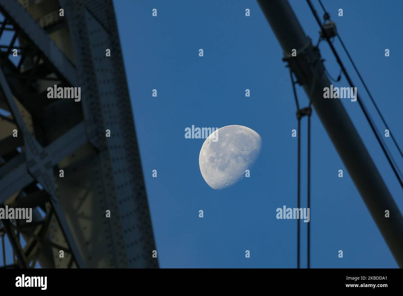 The moon through Williamsburg Bridge, a suspension bridge in New York ...