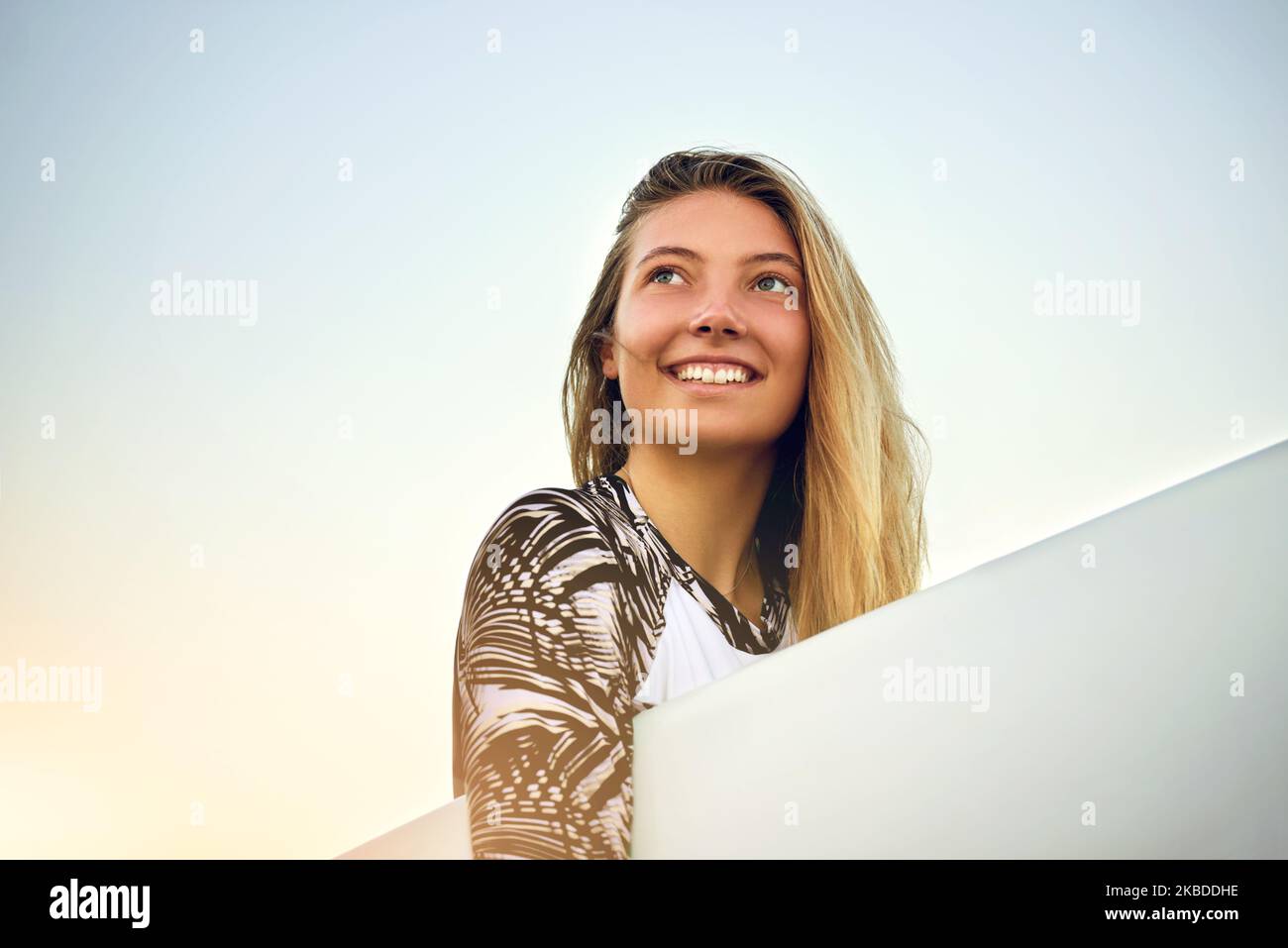 Its a beautiful day for a surf. Low angle shot of an attractive young ...