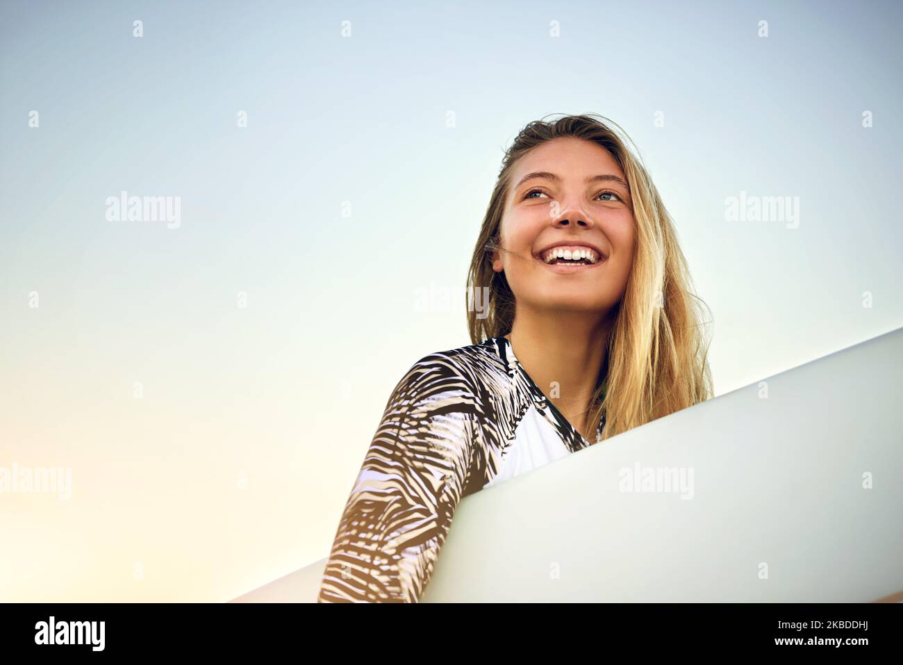 Surfing makes her smile. Low angle shot of an attractive young female ...
