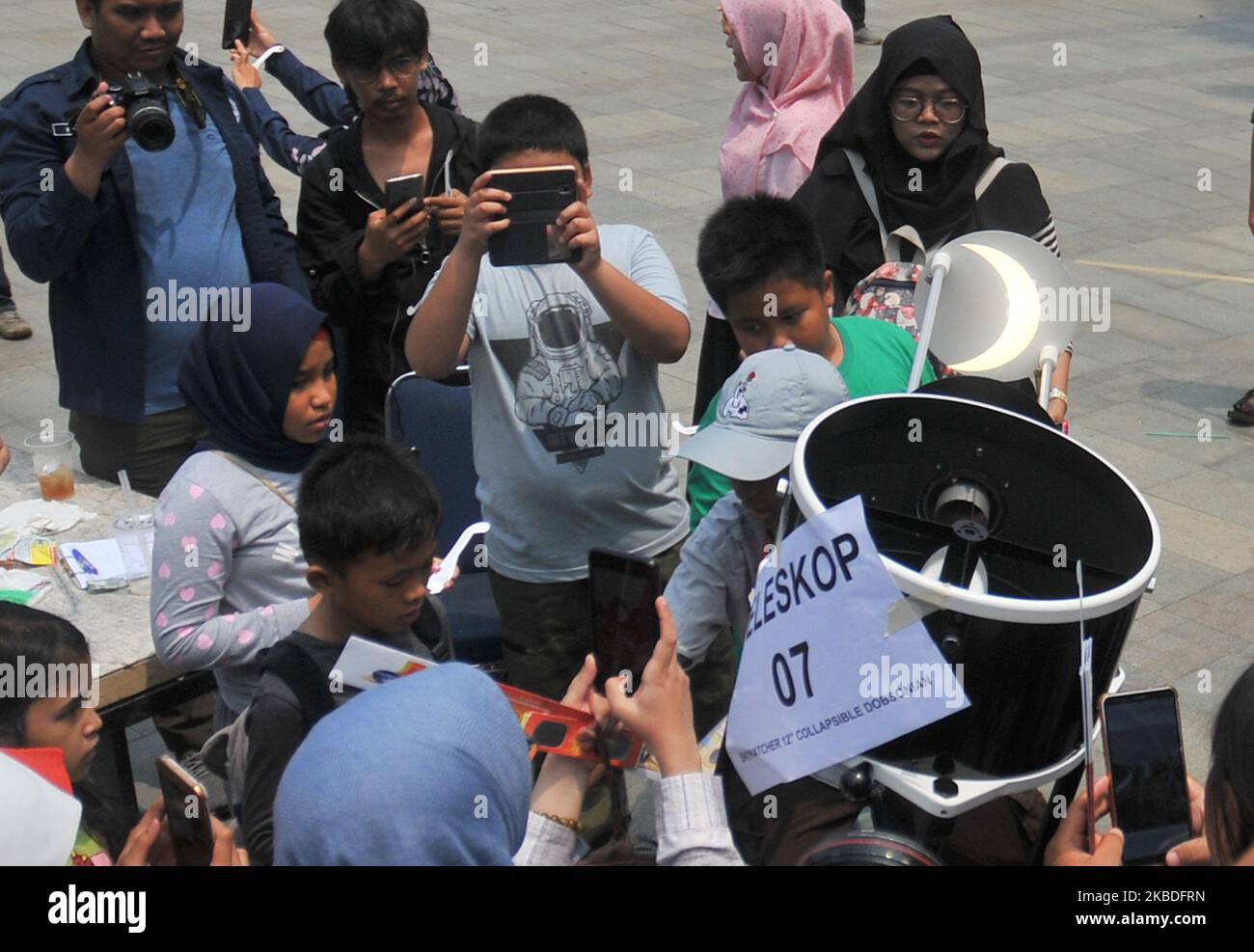 Visitors observe the phenomenon of a partial solar eclipse (GMP ...