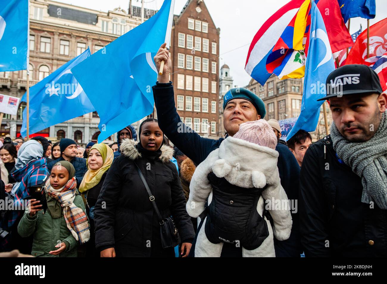 A man holding a baby is also holding a blue Turkish flag during the ...
