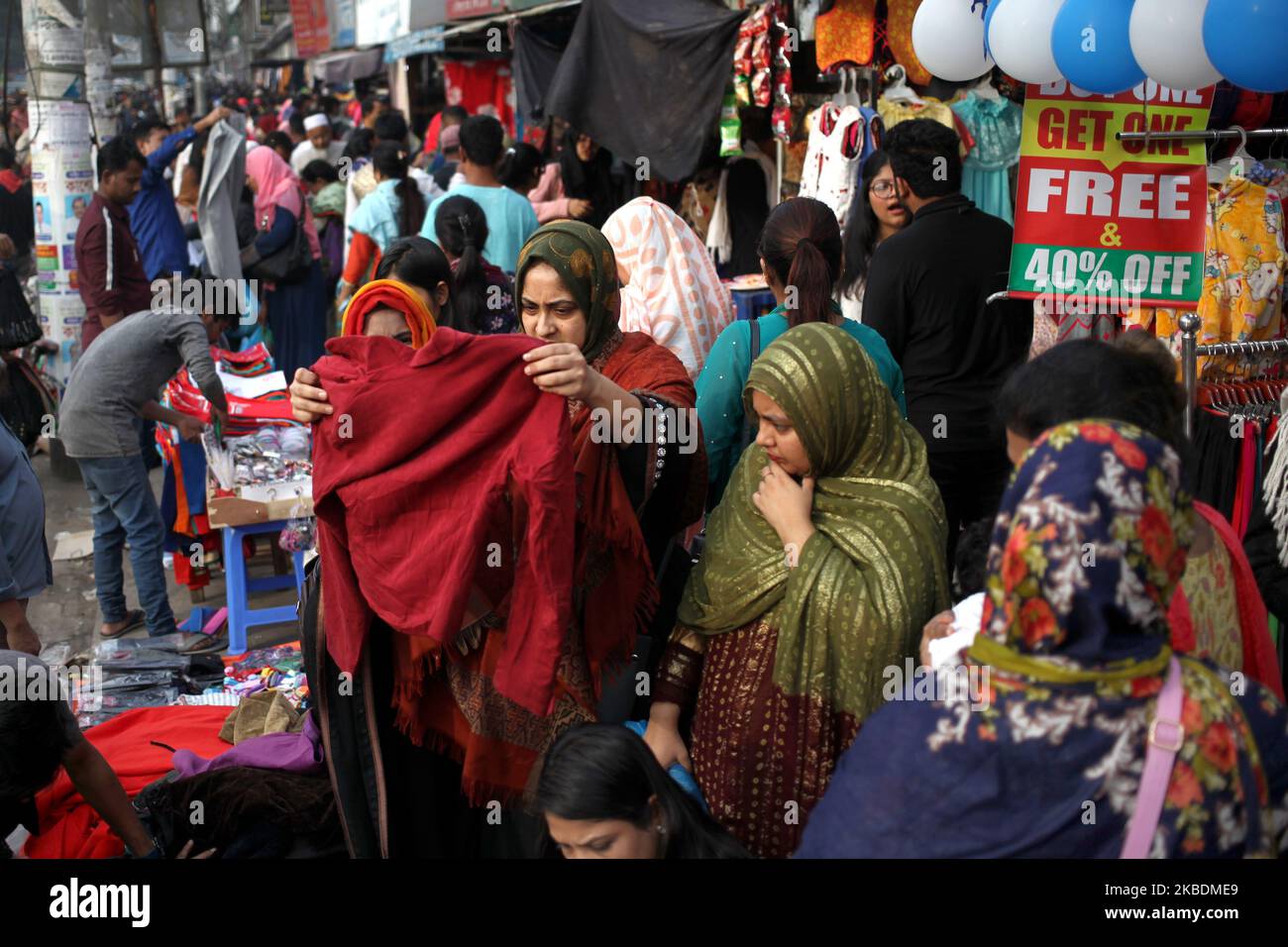 Women seen buying winter cloth from a roadside market in Dhaka ...