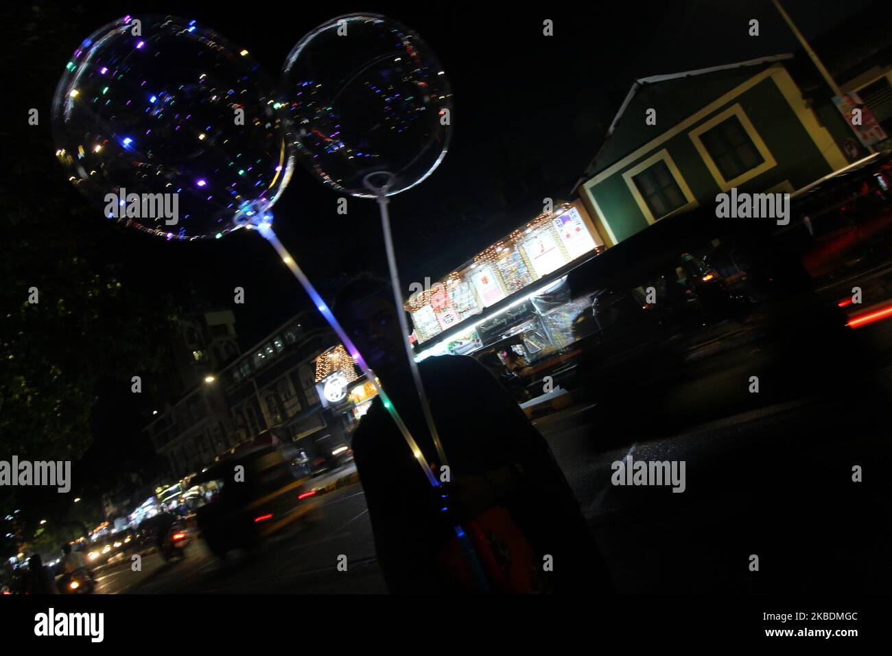 A girl sells light balloons at a roadside in Mumbai, India on 31 ...