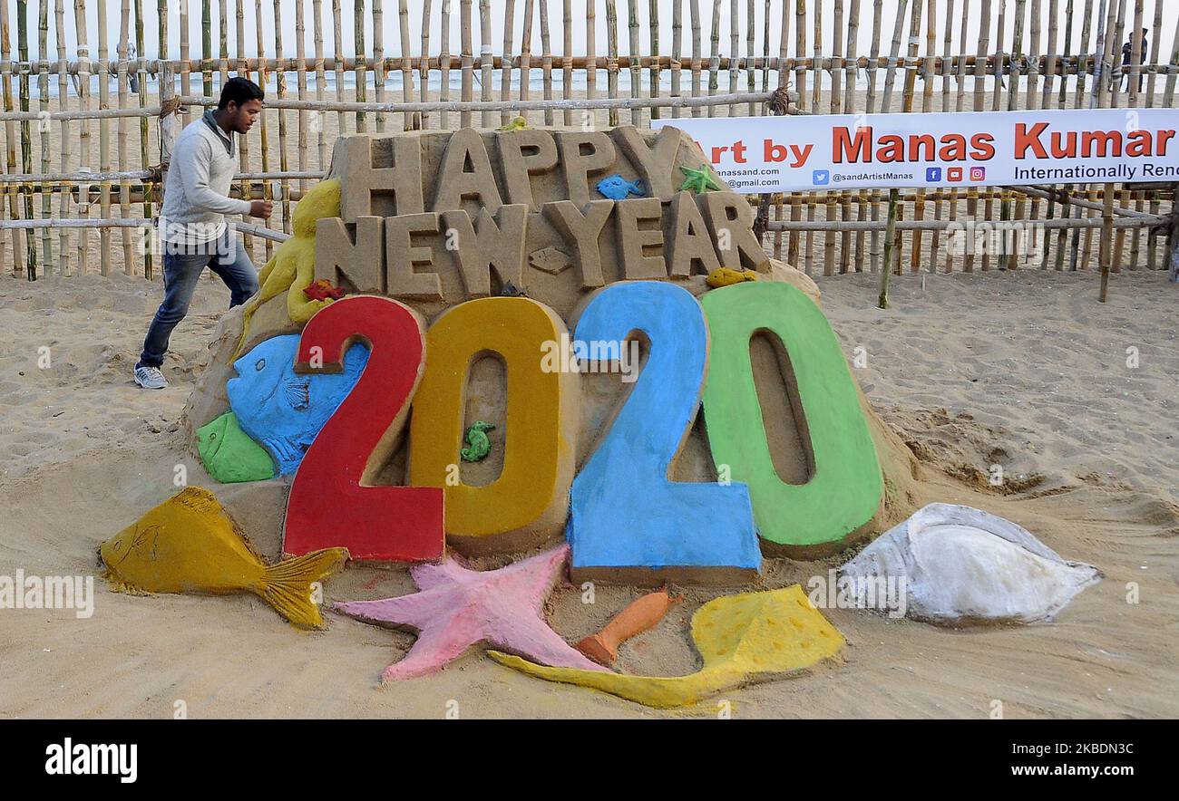 A new year 2020 sand sculpture is seen at the Bay of Bengal Sea's ...