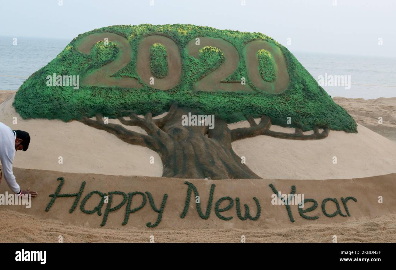 A new year 2020 sand sculpture is seen at the Bay of Bengal Sea's ...