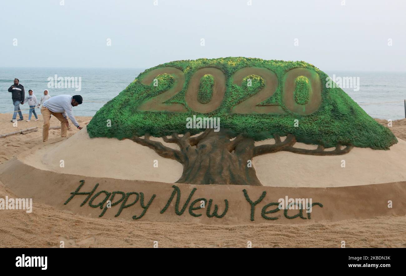 A new year 2020 sand sculpture is seen at the Bay of Bengal Sea's ...
