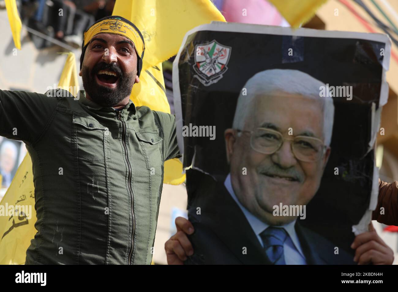 Supporters of the Palestinian Fatah movement, carry the portrait of ...