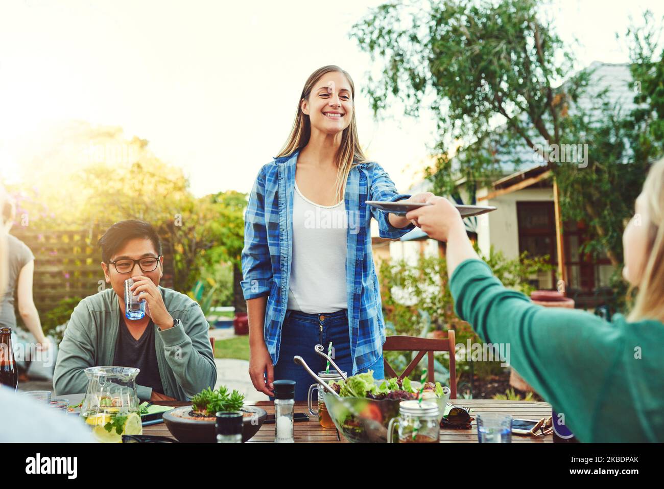 Oh thank you my dear. two young women passing an empty plate to each ...
