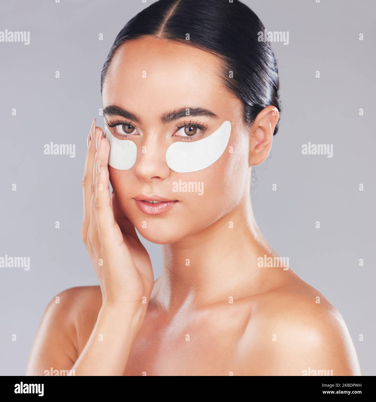 Eye patches, skincare and face of woman isolated on a gray studio ...