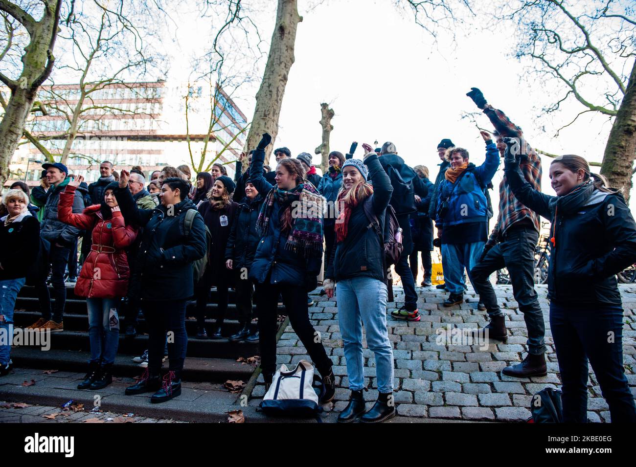 A group of XR activists are making an agreement symbol during a meeting ...