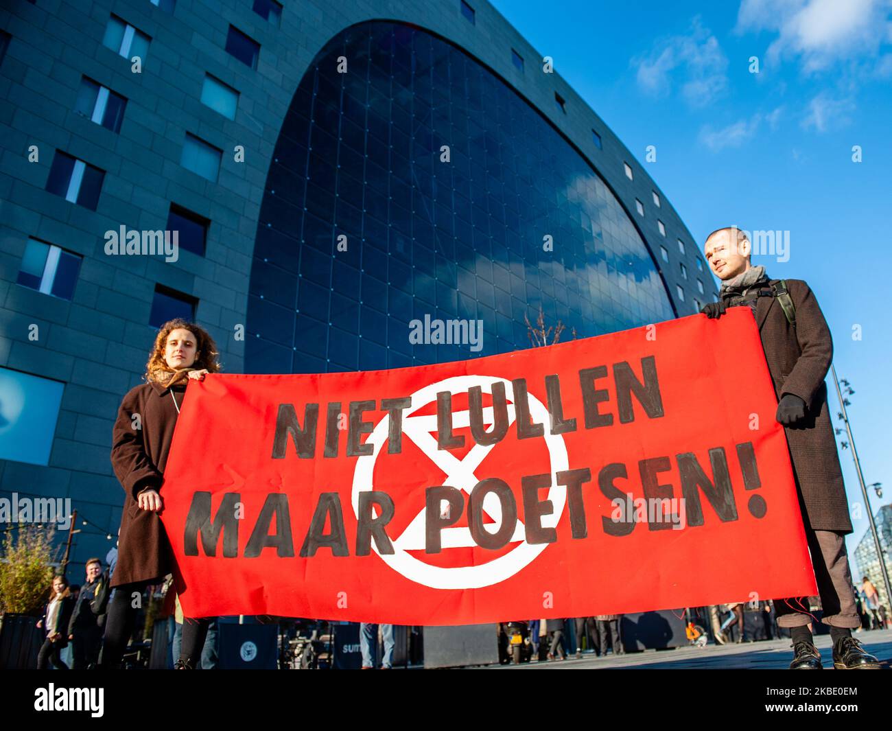 Two XR activists are holding a banner during a Die-in action carried by ...