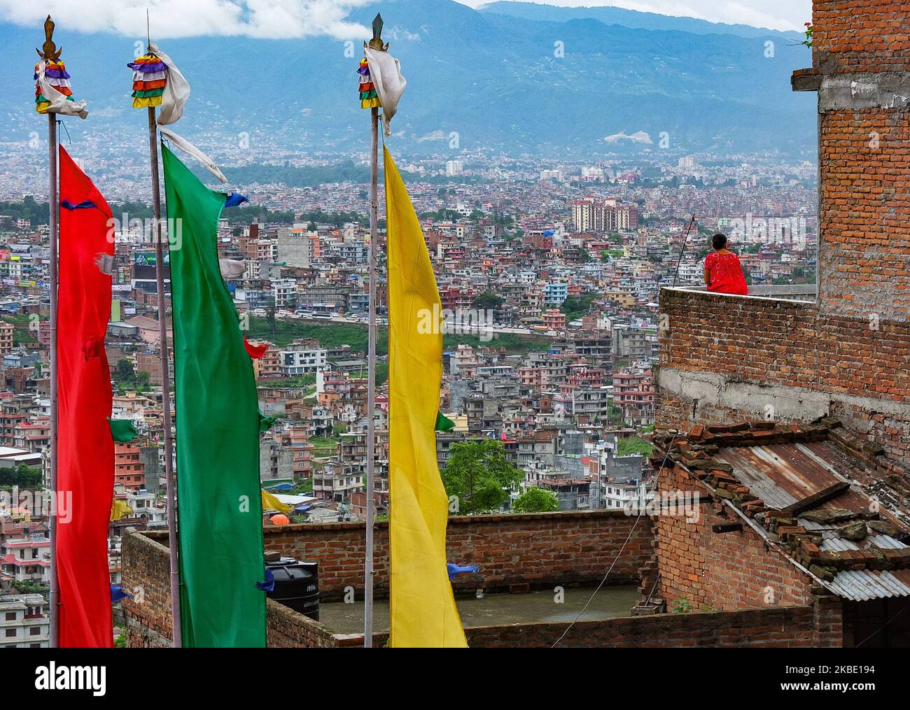 A woman looks out upon the city of Kathmandu, Nepal on a clear summer ...