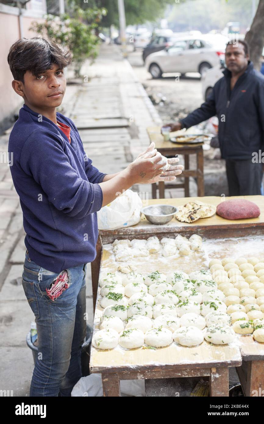 A man is preparing traditional chapati (indian bread) at the street ...