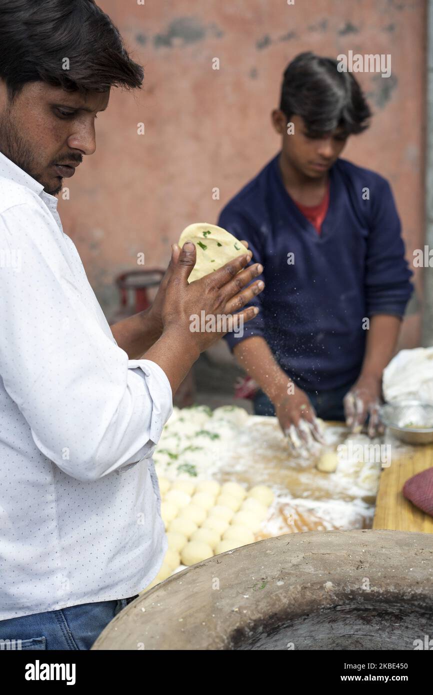 Men prepare traditional chapati (indian bread) at the street food stand ...