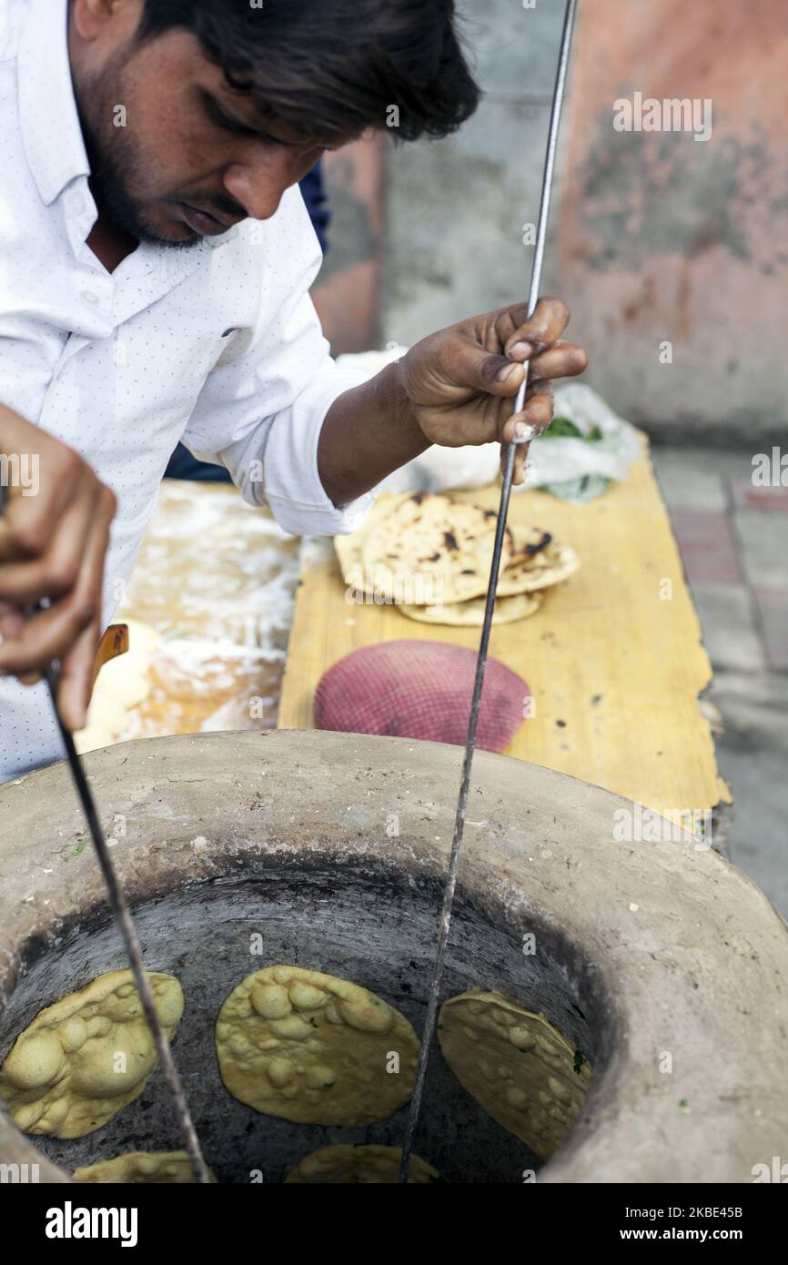 A man is preparing traditional chapati (indian bread) at the street ...