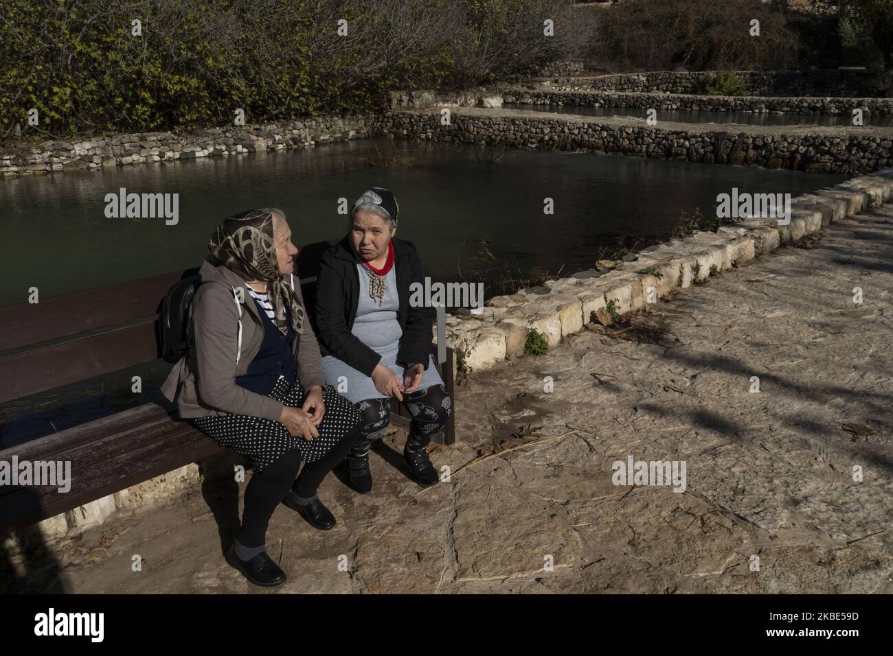 Two pilgrims sitting in the spring of Banias, which is the name of the ...